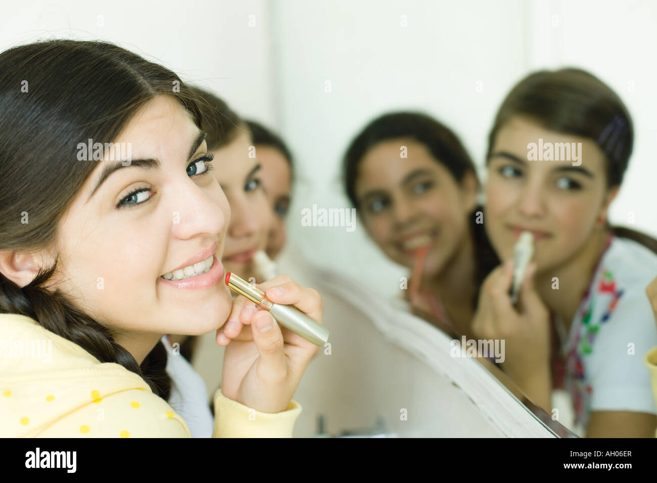 Young female friends putting on make-up Stock Photo - Alamy