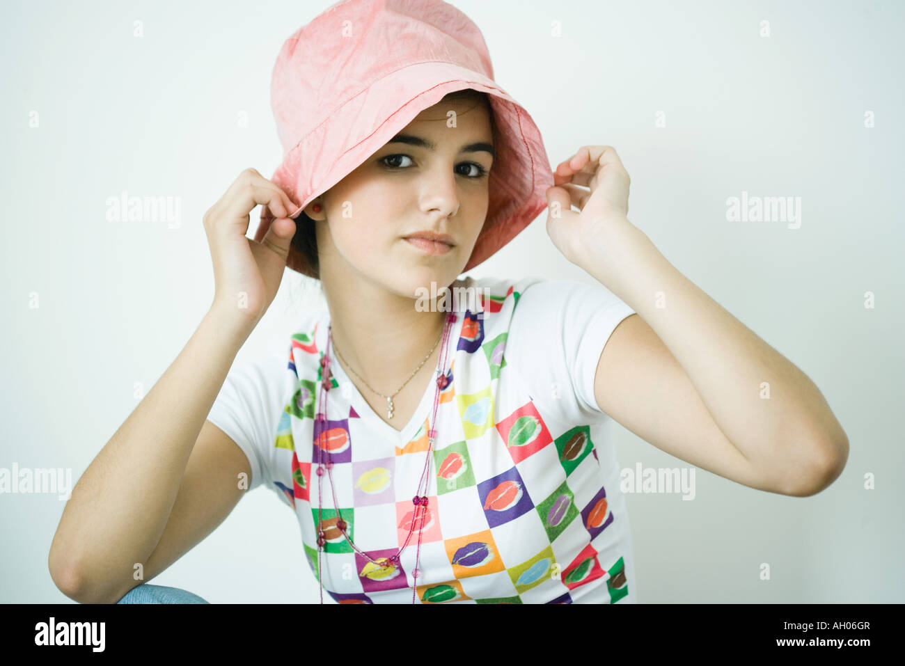 Teen girl putting on hat, portrait Stock Photo - Alamy