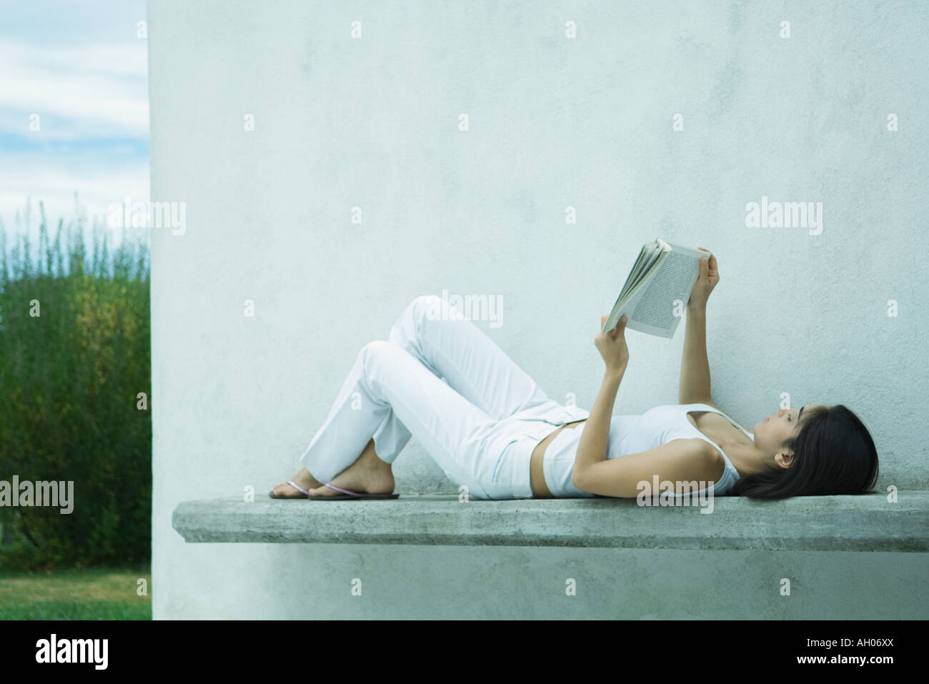 Woman lying on back, reading book Stock Photo - Alamy