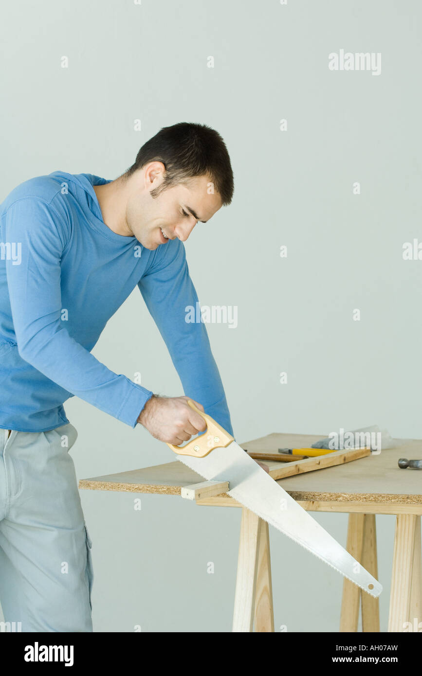 Man sawing wood plank Stock Photo - Alamy