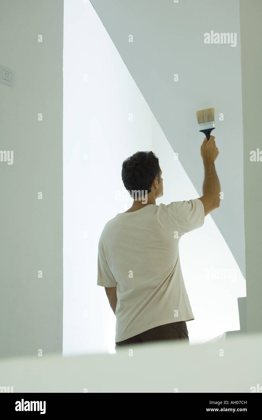 Man painting wall with paintbrush Stock Photo - Alamy