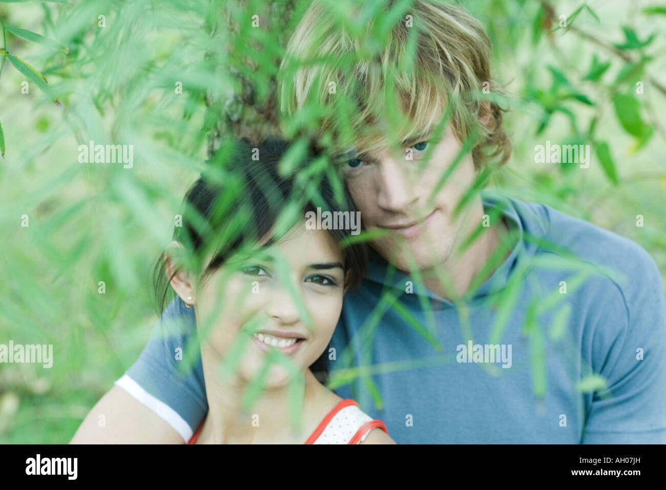 Young couple under branches of tree, portrait Stock Photo - Alamy