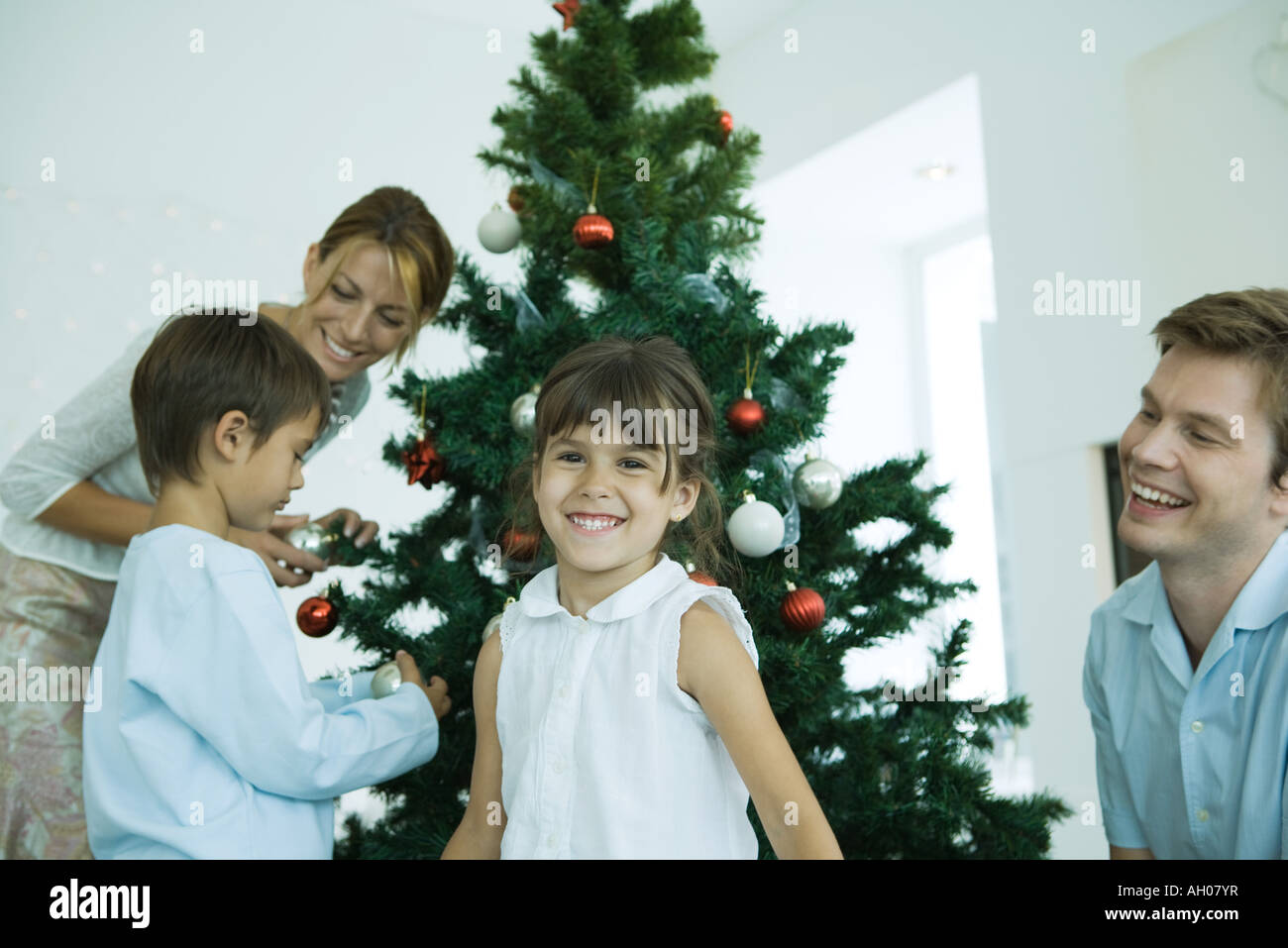 Family decorating Christmas tree Stock Photo - Alamy