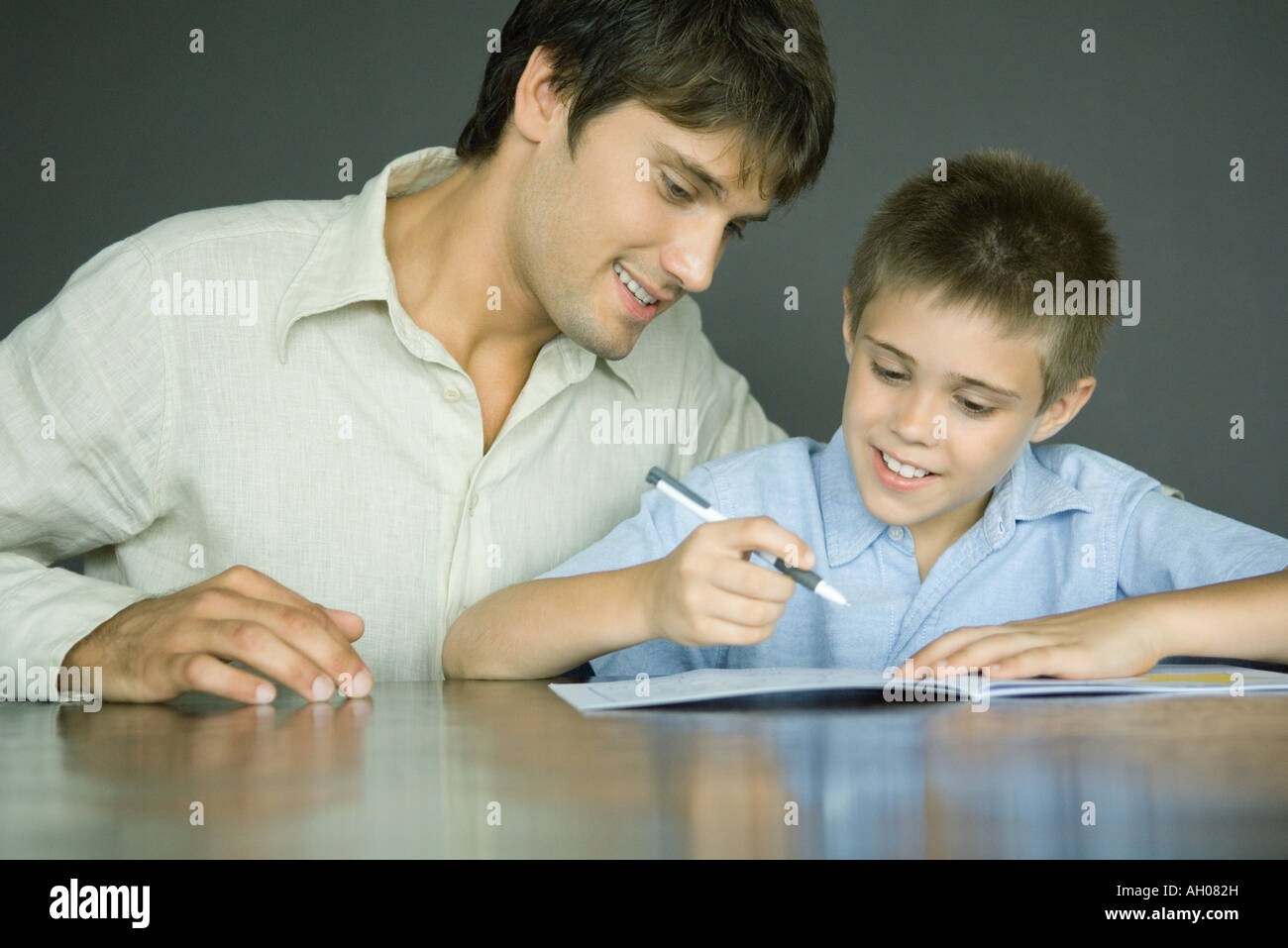Man helping boy with homework Stock Photo - Alamy