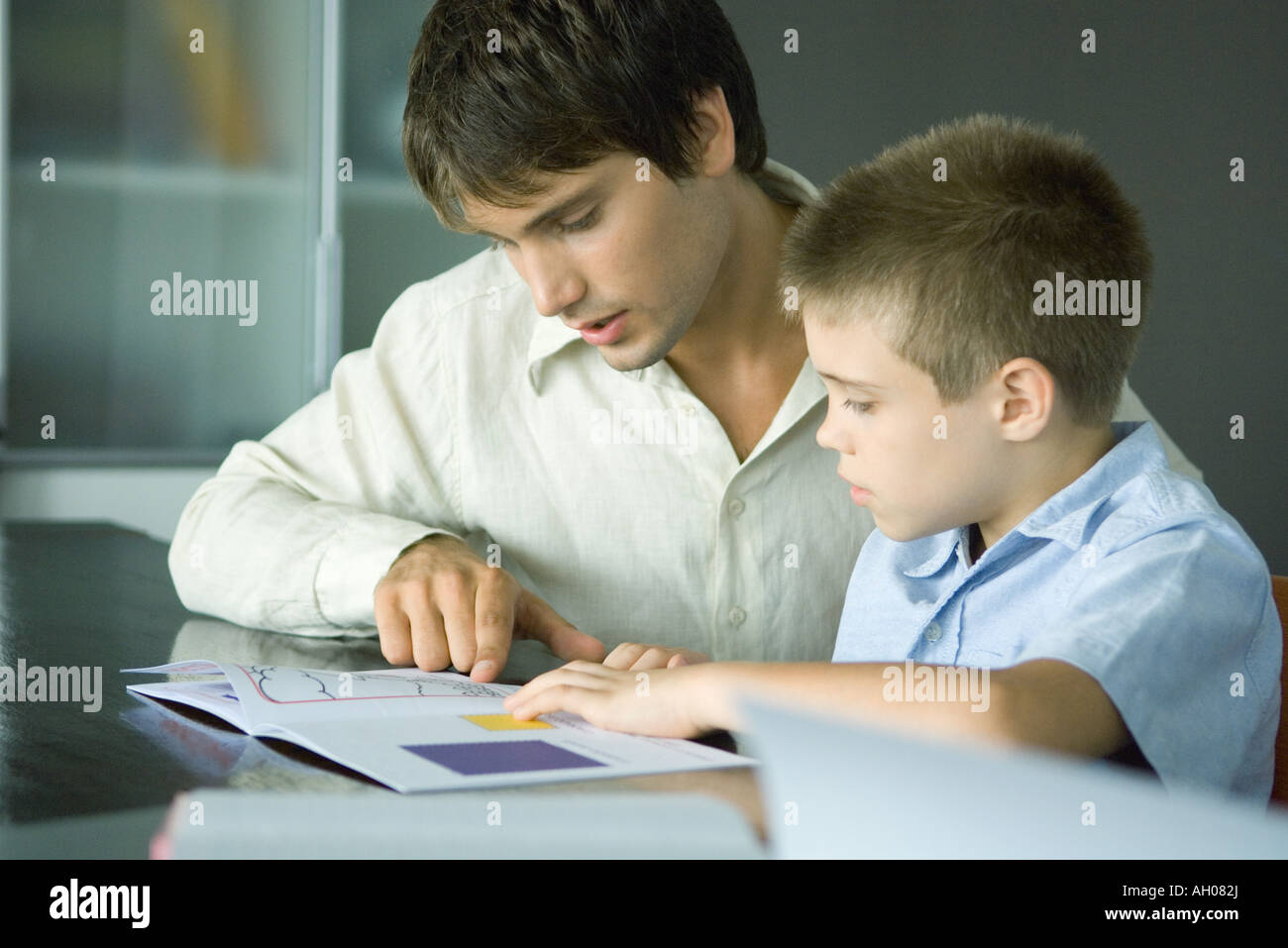 Man helping boy with homework Stock Photo - Alamy