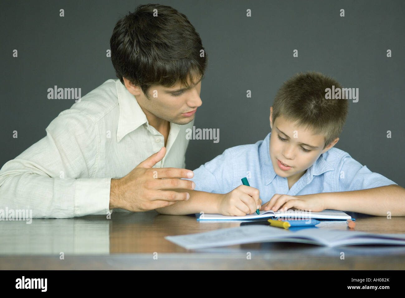 Man helping boy with homework Stock Photo - Alamy