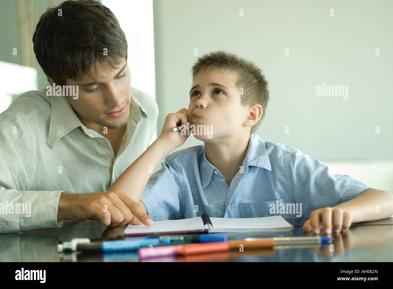 Man helping boy with homework Stock Photo - Alamy