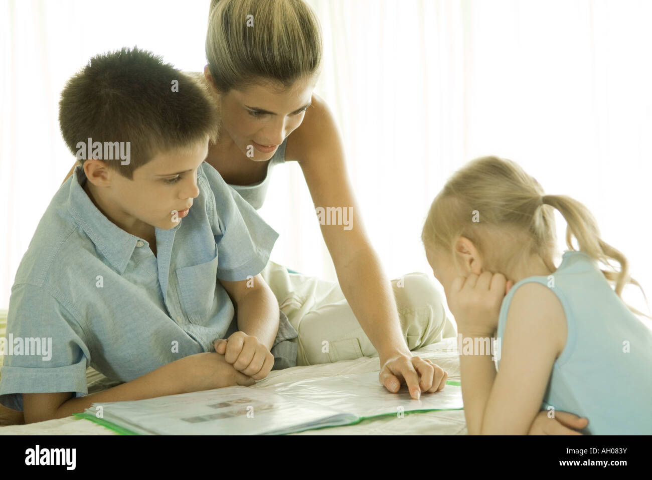 Mother helping children with homework Stock Photo - Alamy