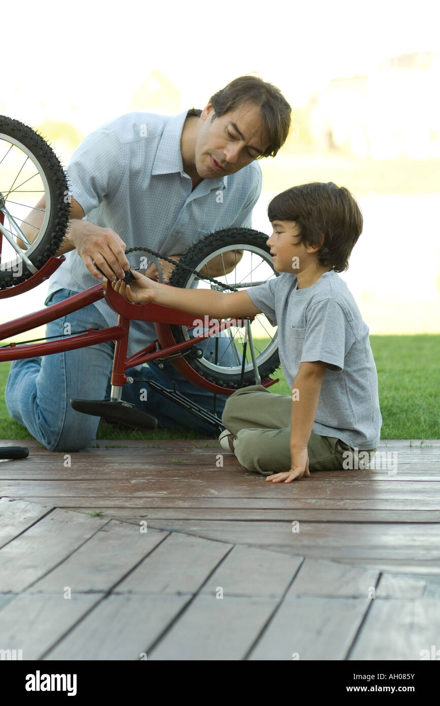 Father and son fixing bike together Stock Photo - Alamy