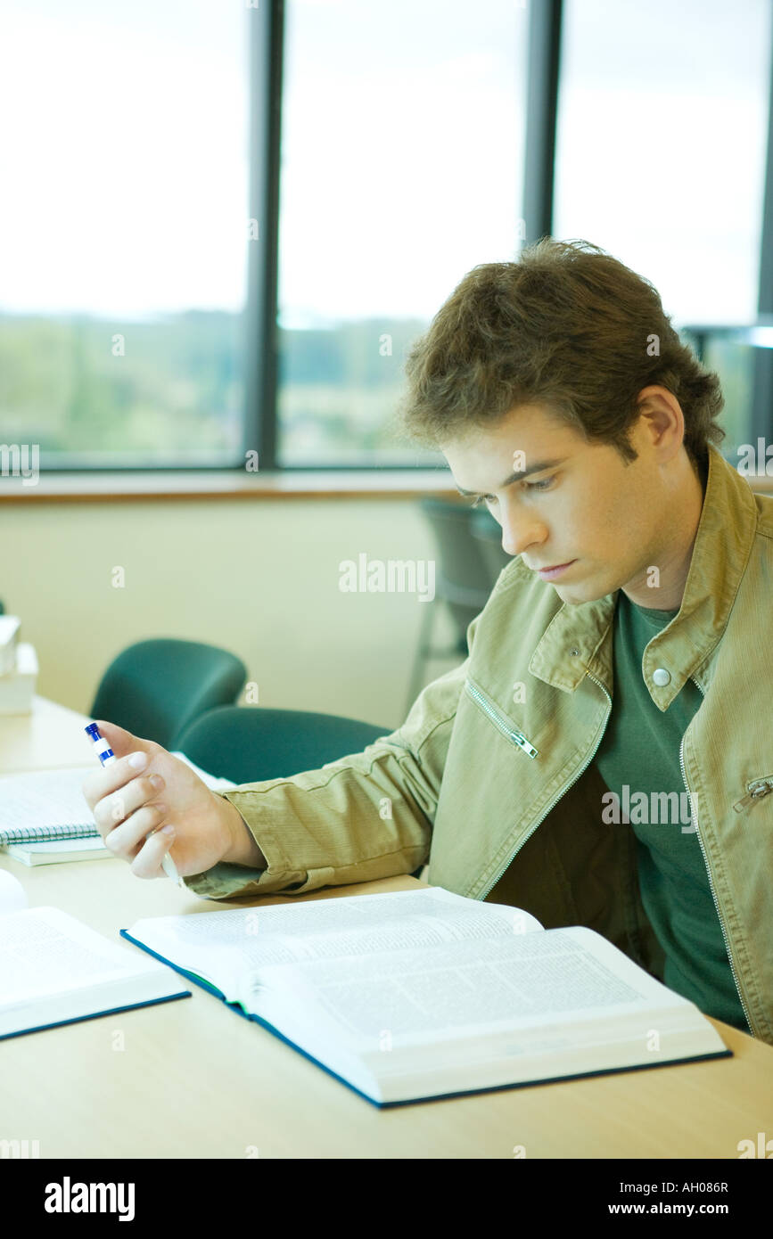 Young man studying in university library Stock Photo - Alamy