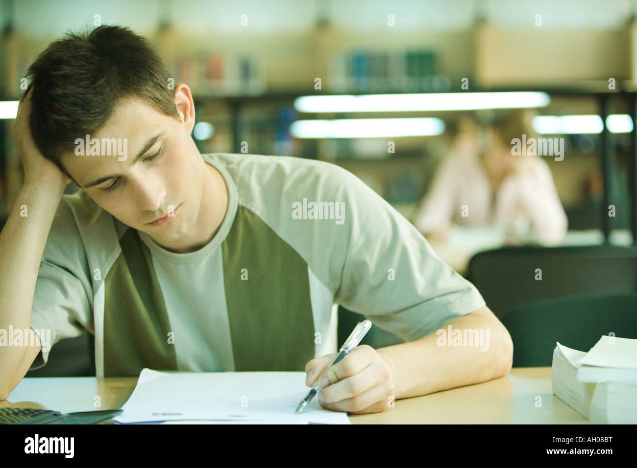 Male student studying in library Stock Photo - Alamy