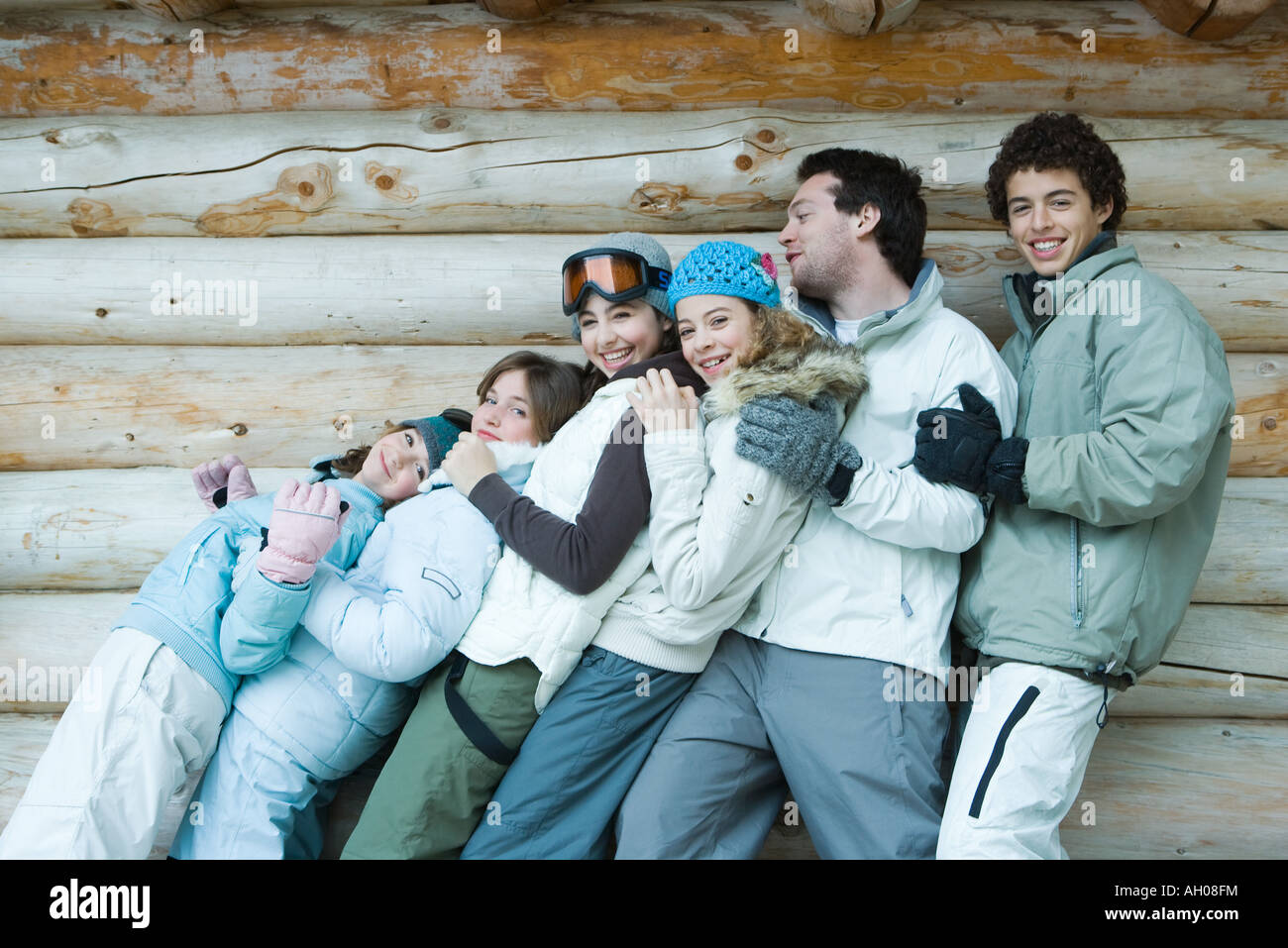 Group in winter clothes falling back onto each other, three quarter ...