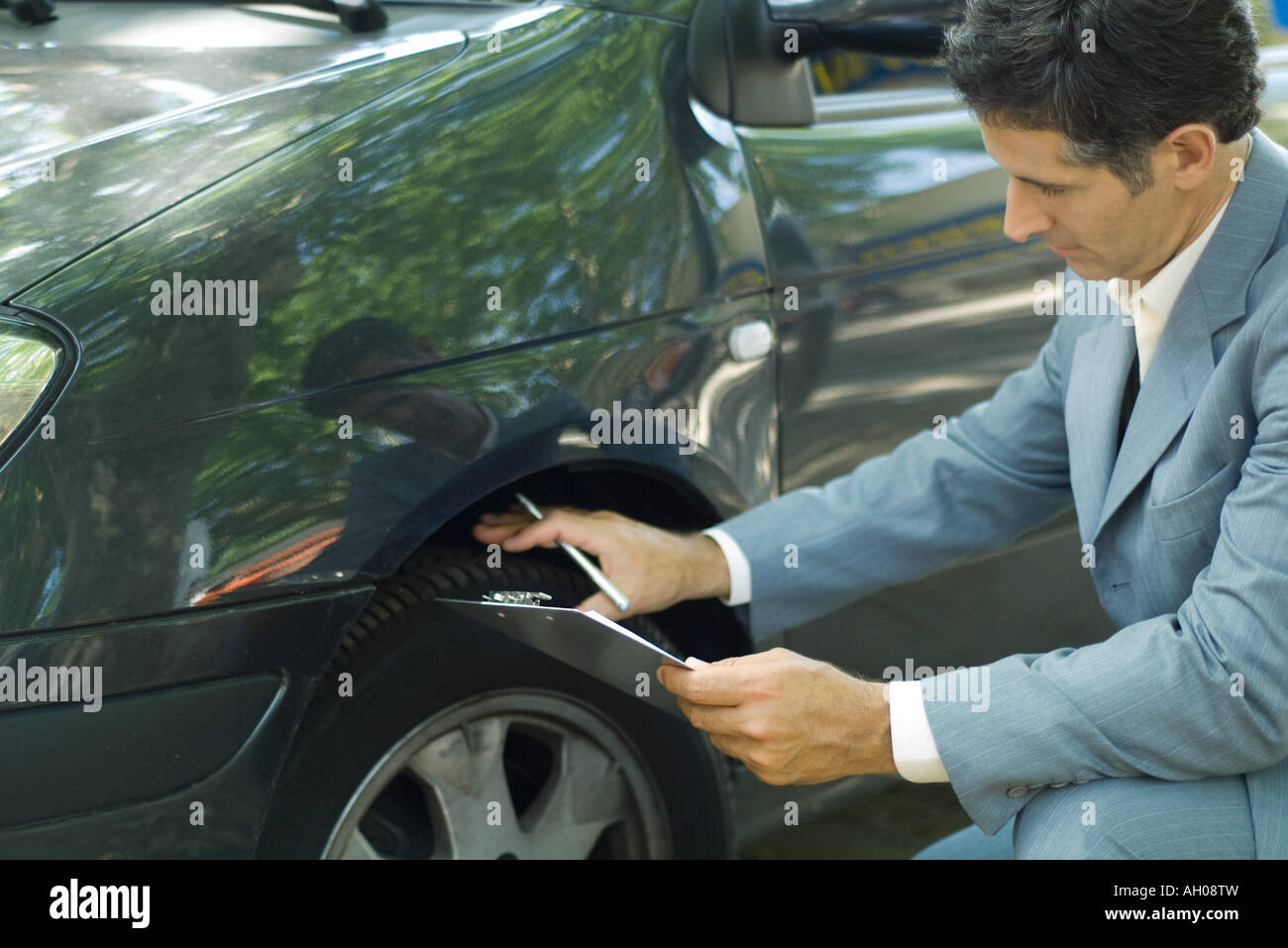 Mature man in suit inspecting car Stock Photo - Alamy