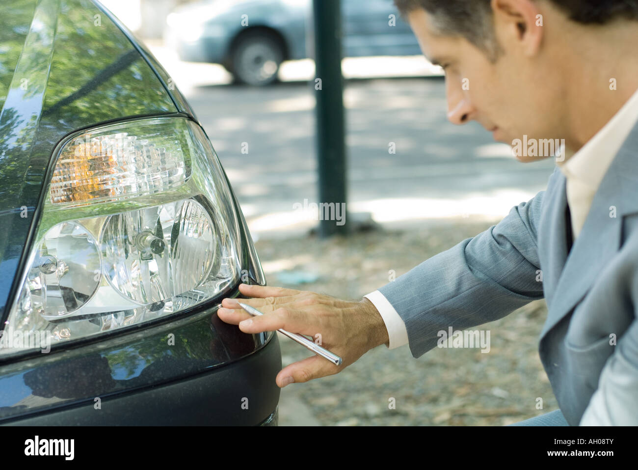 Mature man in suit inspecting car Stock Photo - Alamy