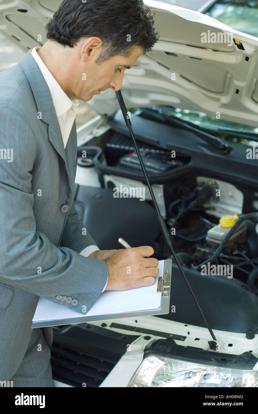 Mature man in suit inspecting car Stock Photo - Alamy