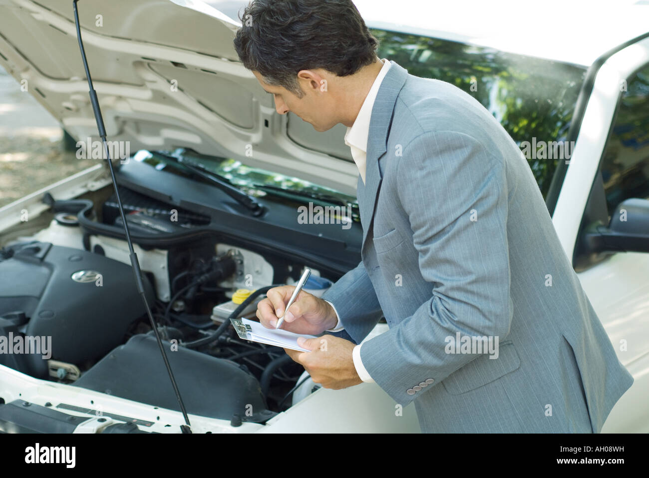 Mature man in suit inspecting car Stock Photo - Alamy
