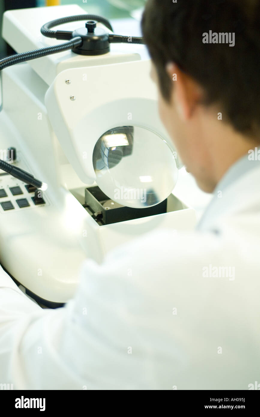 Male lab worker using lab machine, rear view Stock Photo - Alamy