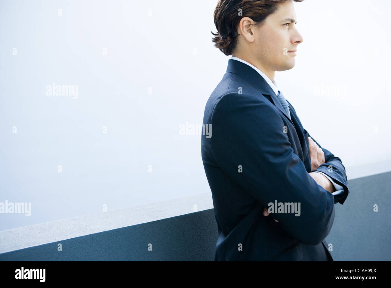 Young businessman standing with arms folded, cropped side view Stock ...