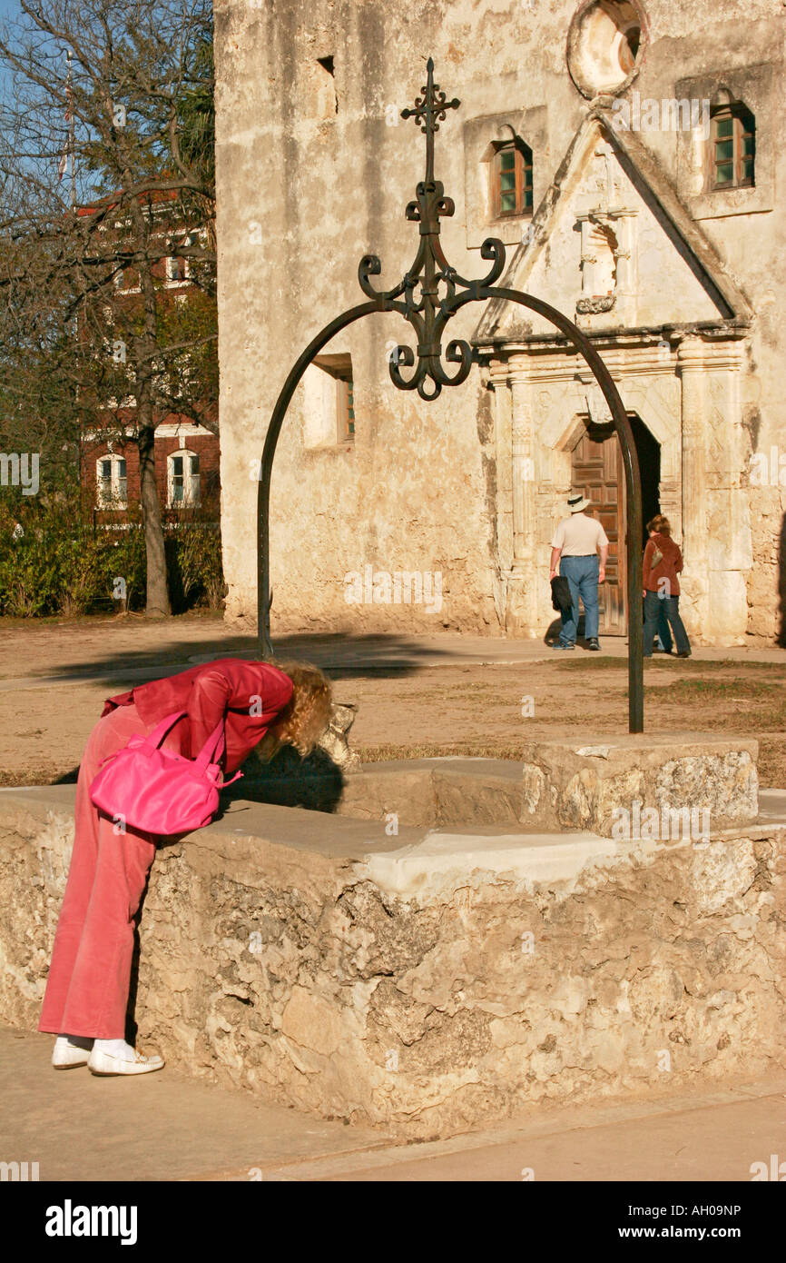Woman looking down water well in front of Mission Concepcion in San ...
