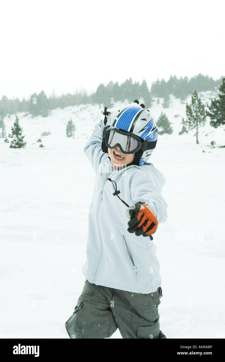 Boy throwing snowball, dressed in ski clothing, three quarter length ...