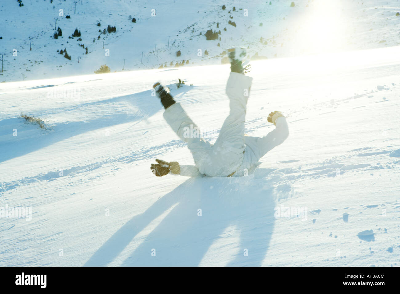 Young skier falling down ski slope, legs in the air, rear view Stock ...