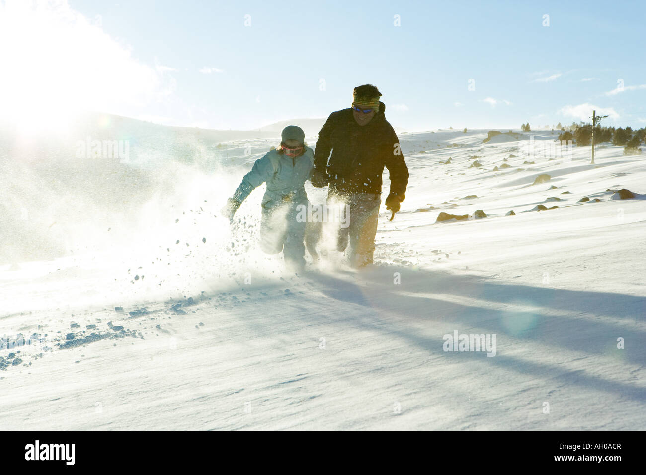Father and daughter running in snow together, full length Stock Photo ...