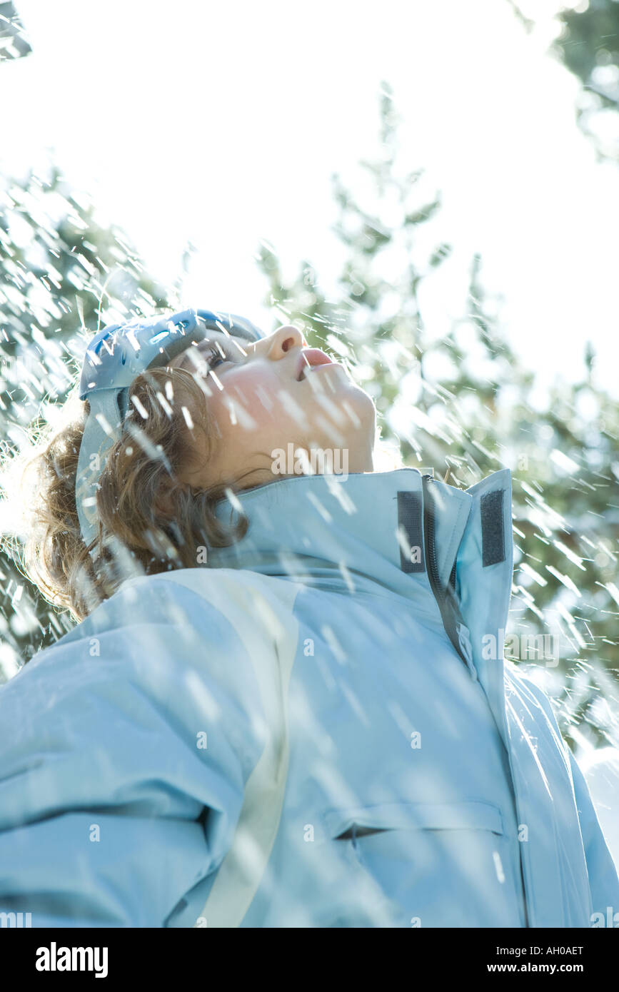 Girl standing in falling snow, head back, looking up Stock Photo - Alamy