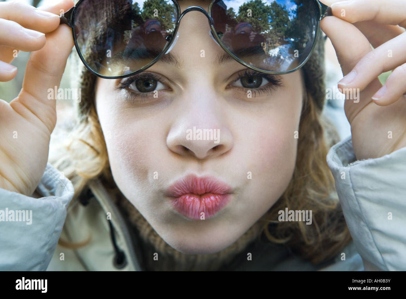 Preteen girl lifting sunglasses, puckering at camera, close-up Stock ...