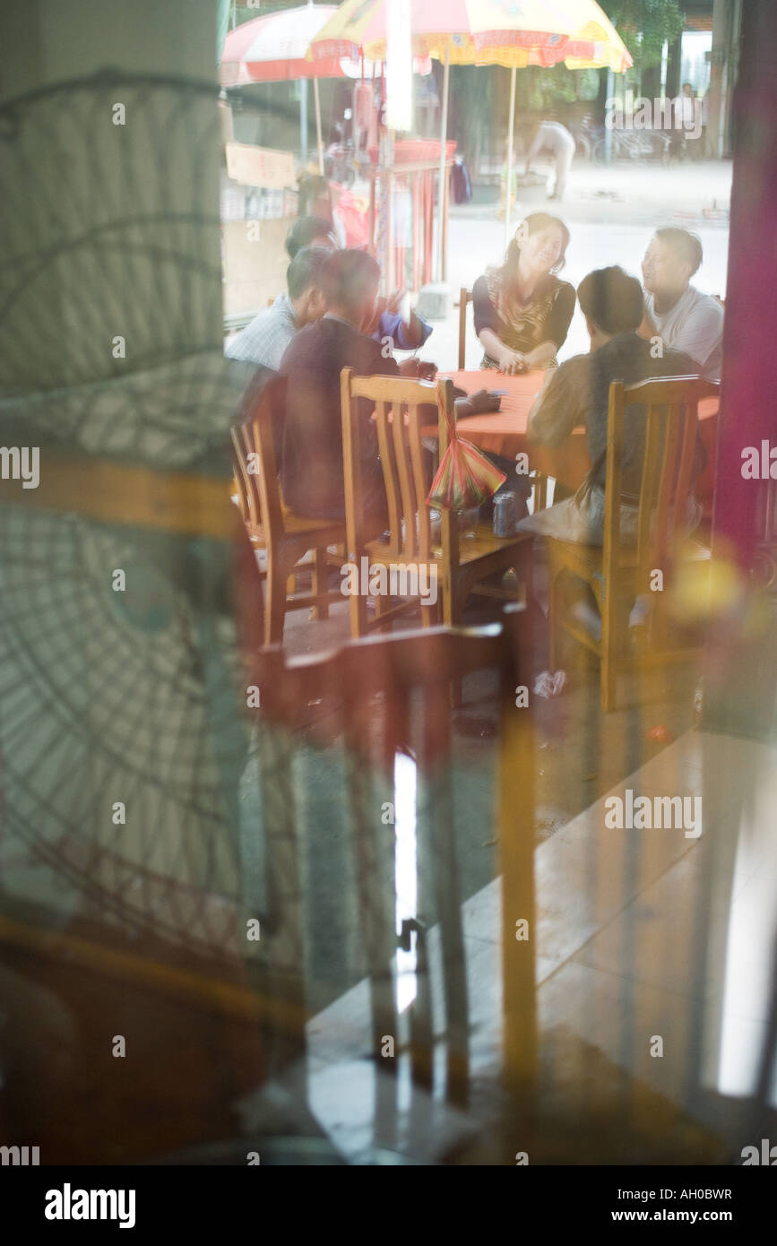 Diners sitting at table outdoors, seen through window Stock Photo - Alamy