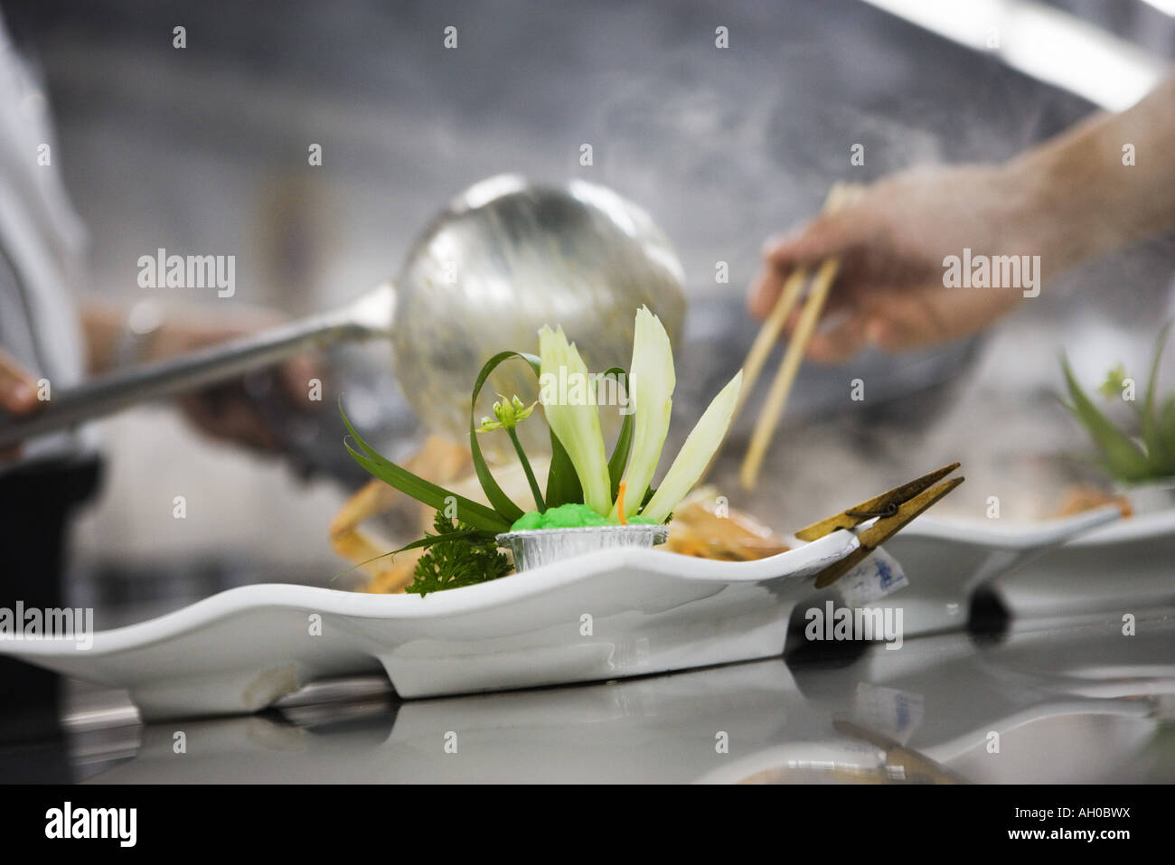 Chefs dressing plates in commercial kitchen Stock Photo - Alamy