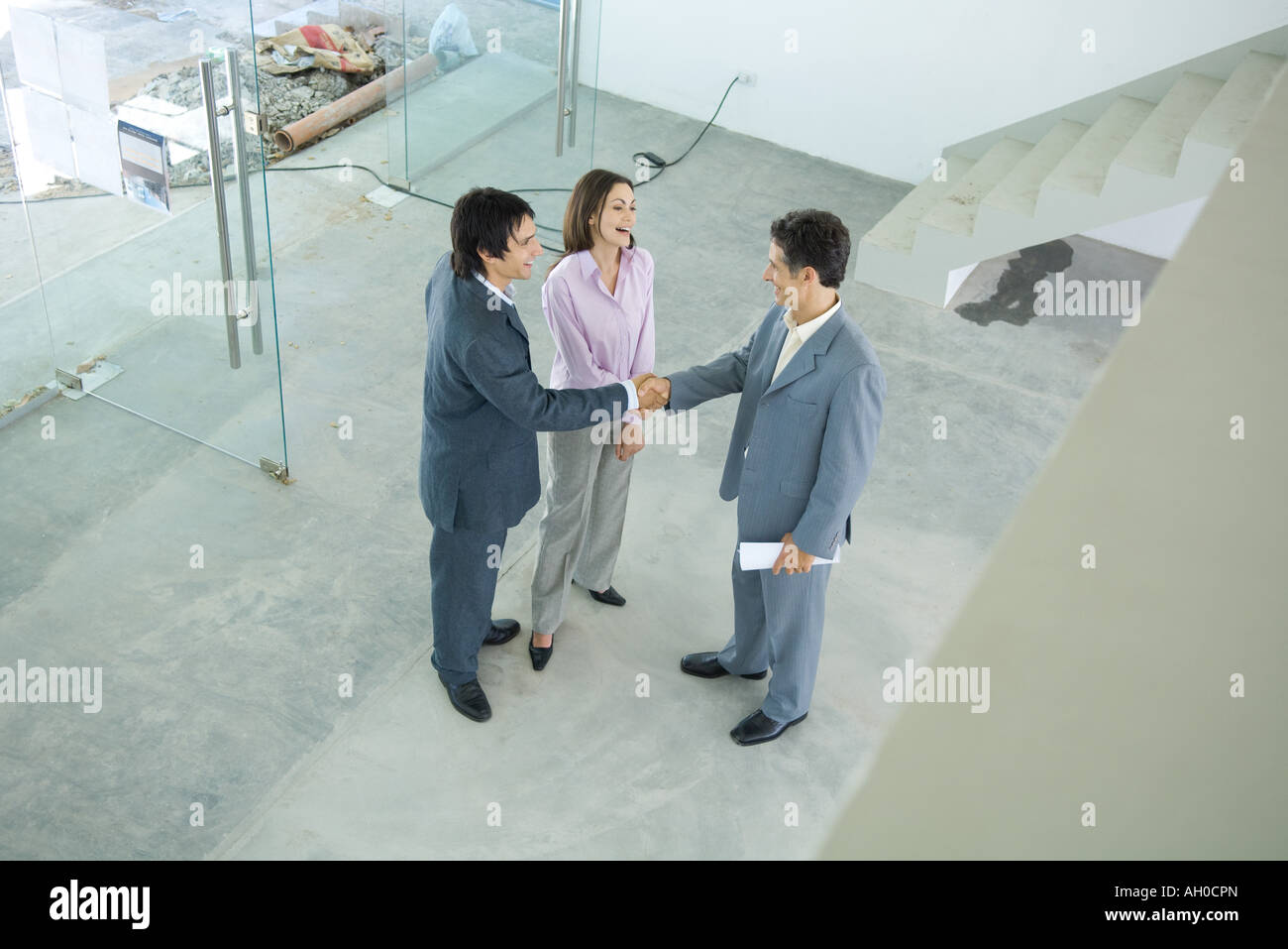 Male real estate agent standing in home interior with young couple ...