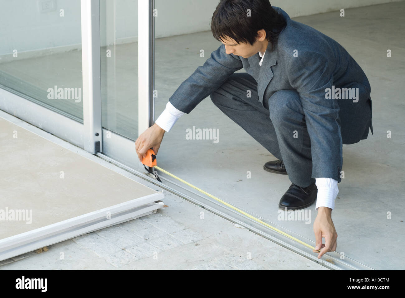 Man in suit measuring doorway Stock Photo - Alamy
