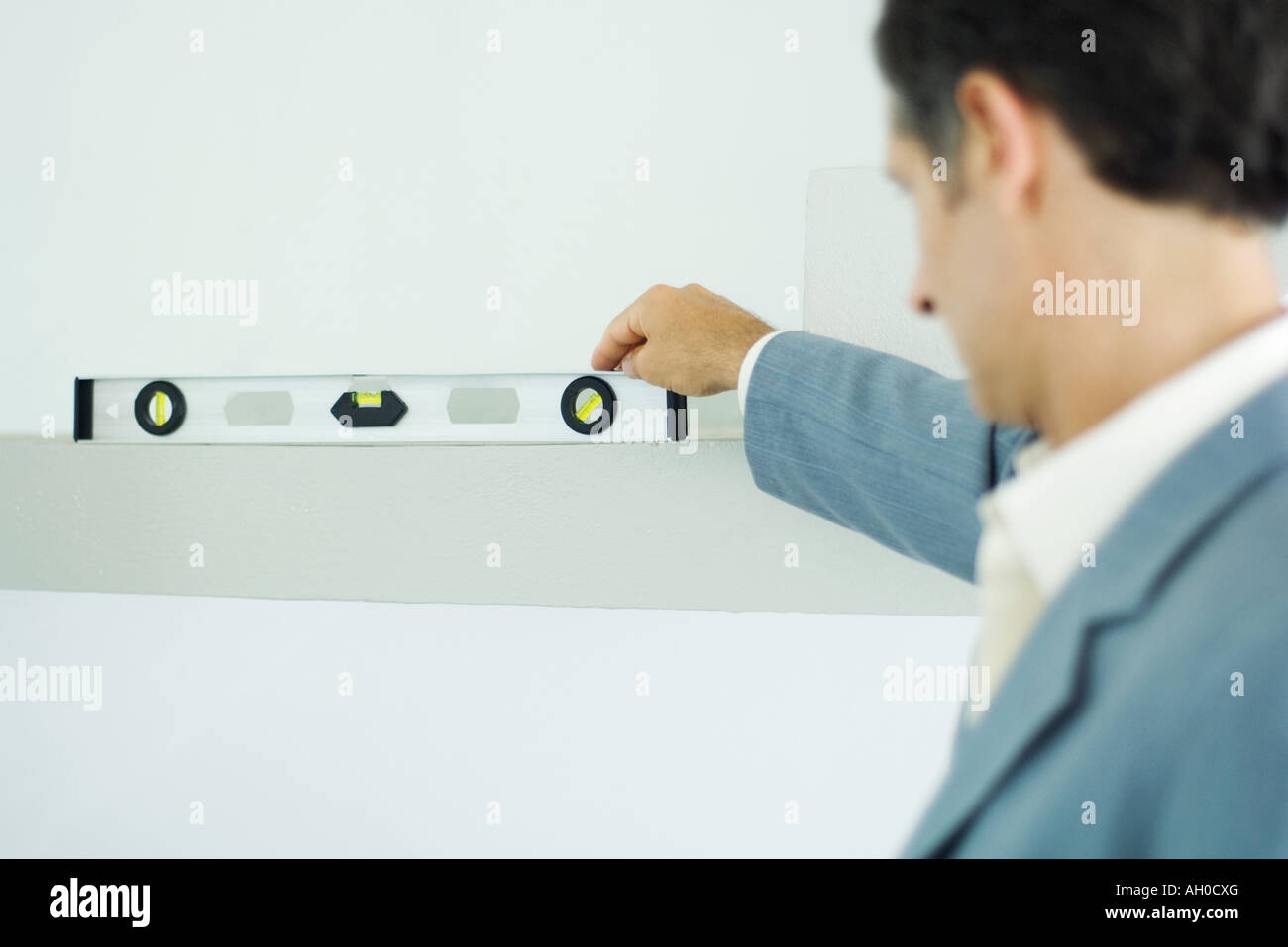 Man in suit using level Stock Photo - Alamy