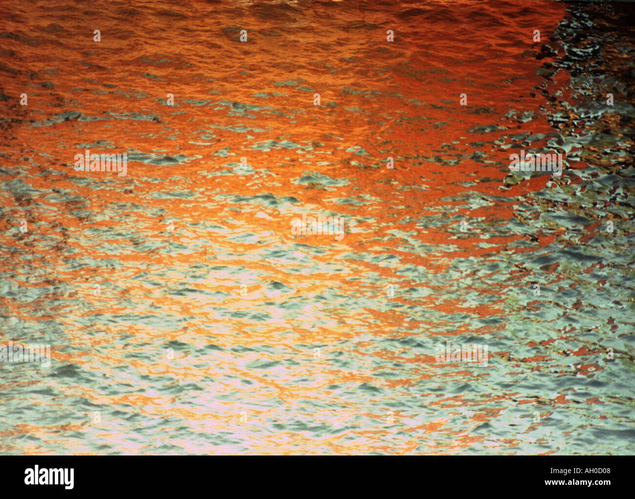 Orange reflection in rippled water Stock Photo - Alamy
