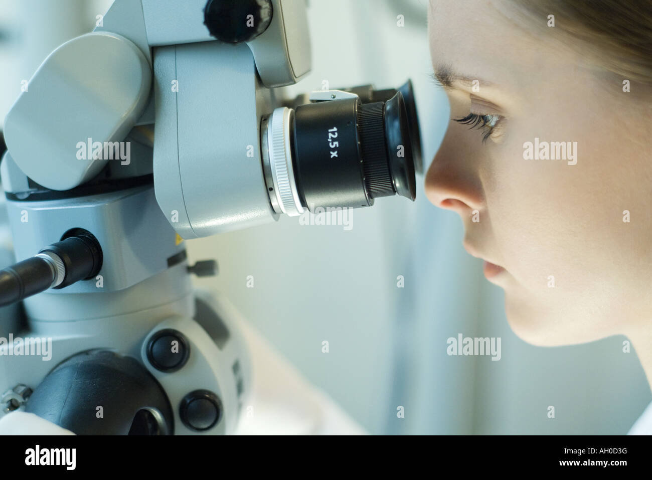 Young woman using microscope Stock Photo - Alamy