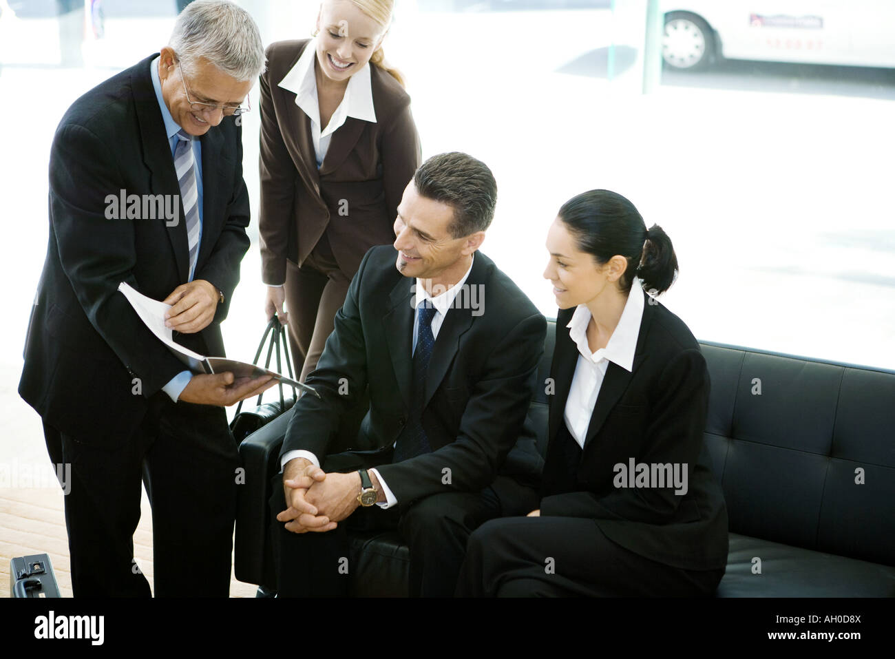 Business associates looking at booklet Stock Photo - Alamy