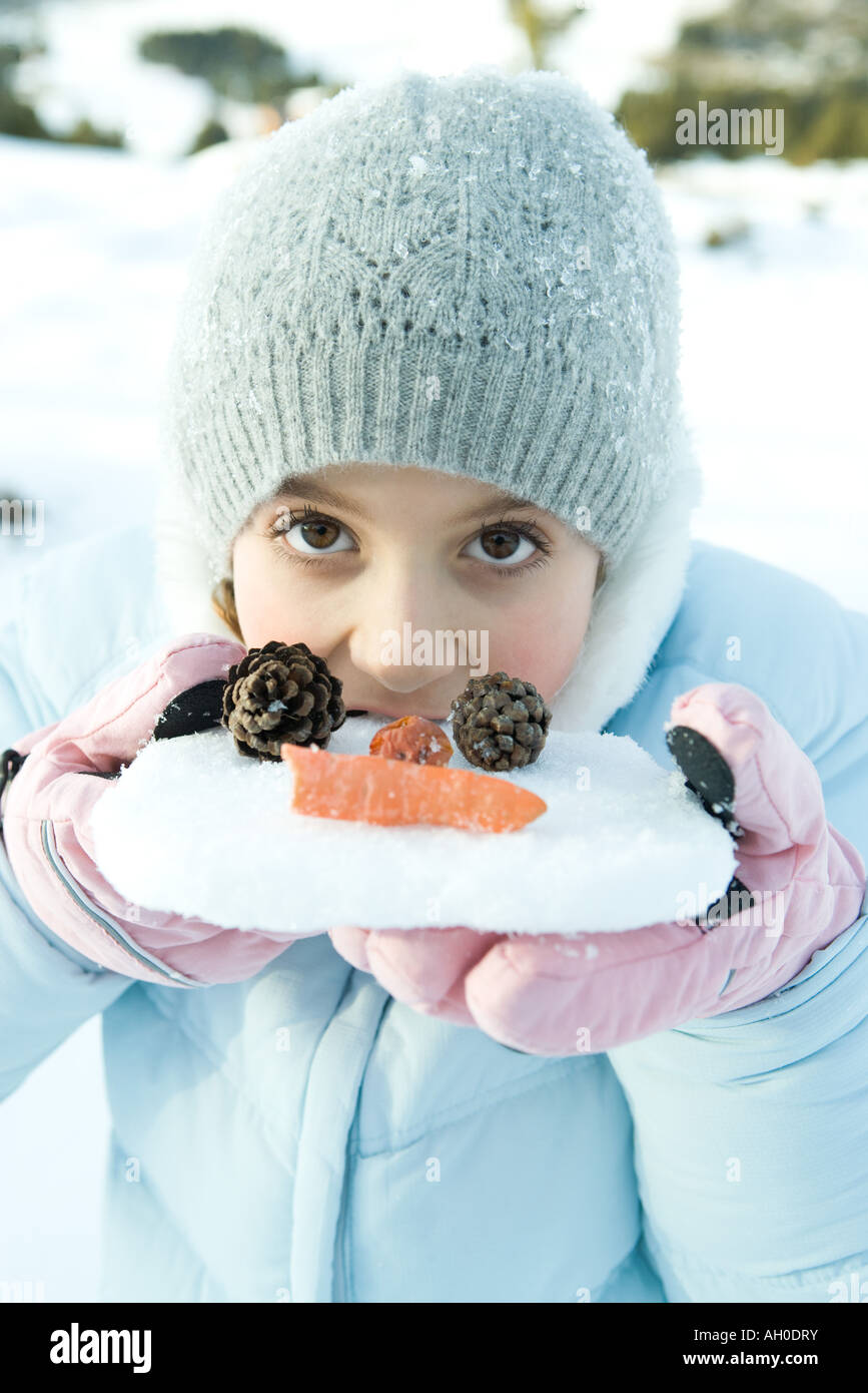 Girl biting into snow, looking at camera, portrait Stock Photo - Alamy