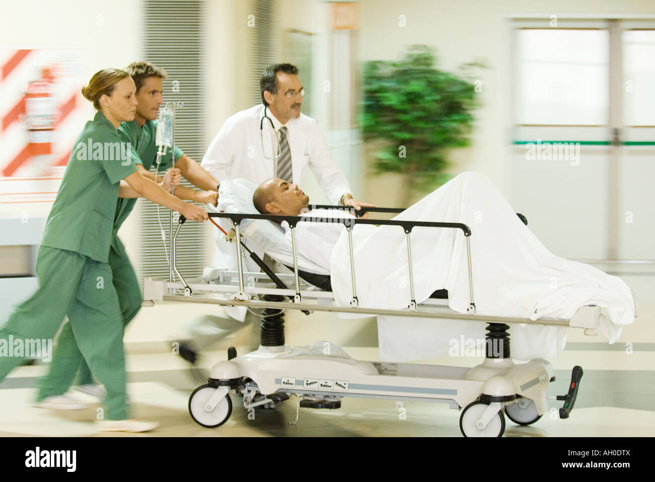 Emergency room staff pushing man on stretcher, blurred motion Stock ...