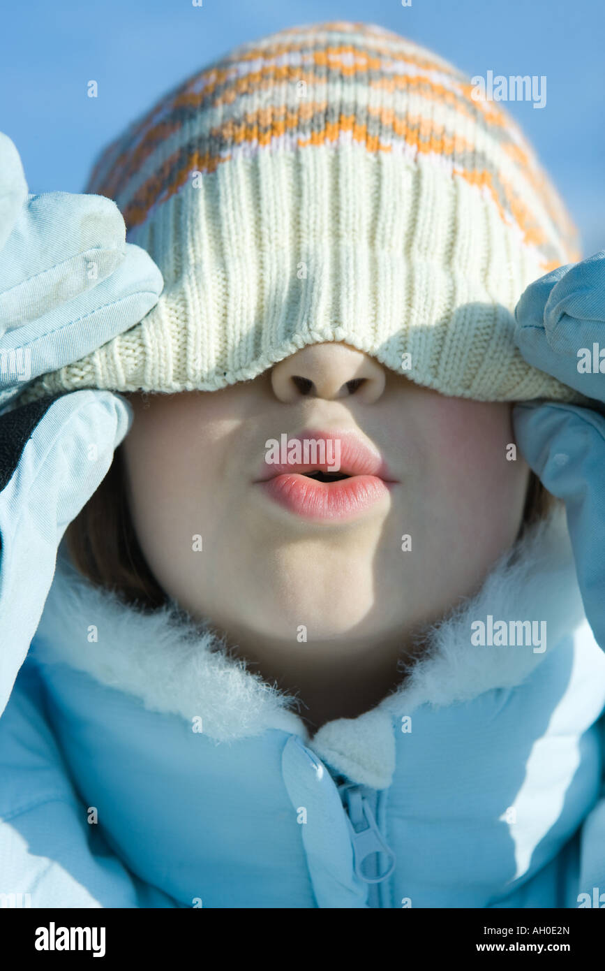 Girl pulling knit hat down over eyes, puckering, close-up Stock Photo ...