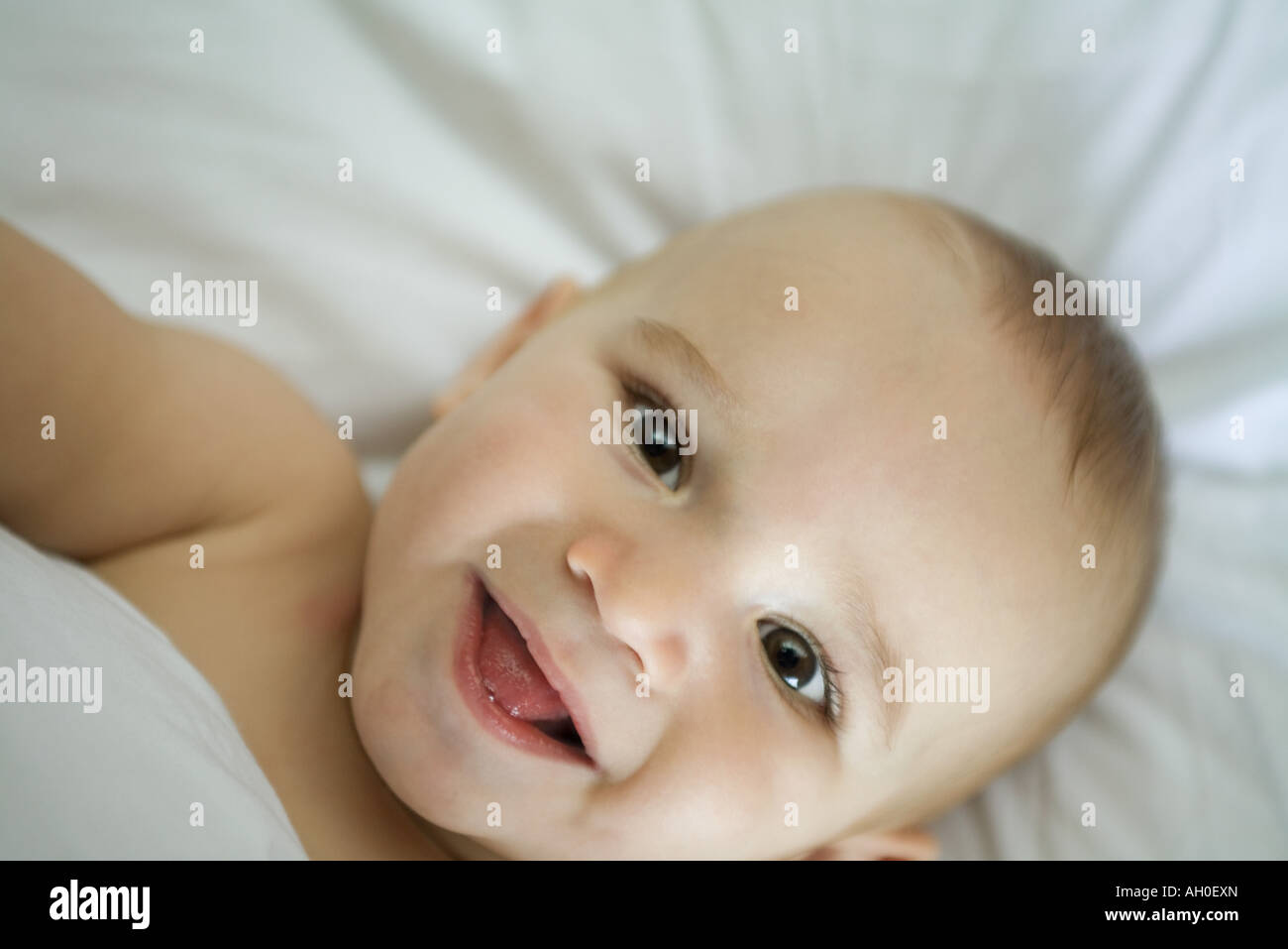 Baby lying on back, smiling at camera, head and shoulders Stock Photo ...