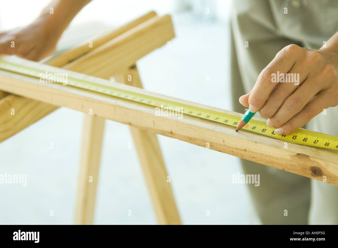 Unrecognizable person measuring wood with measuring tape Stock Photo ...