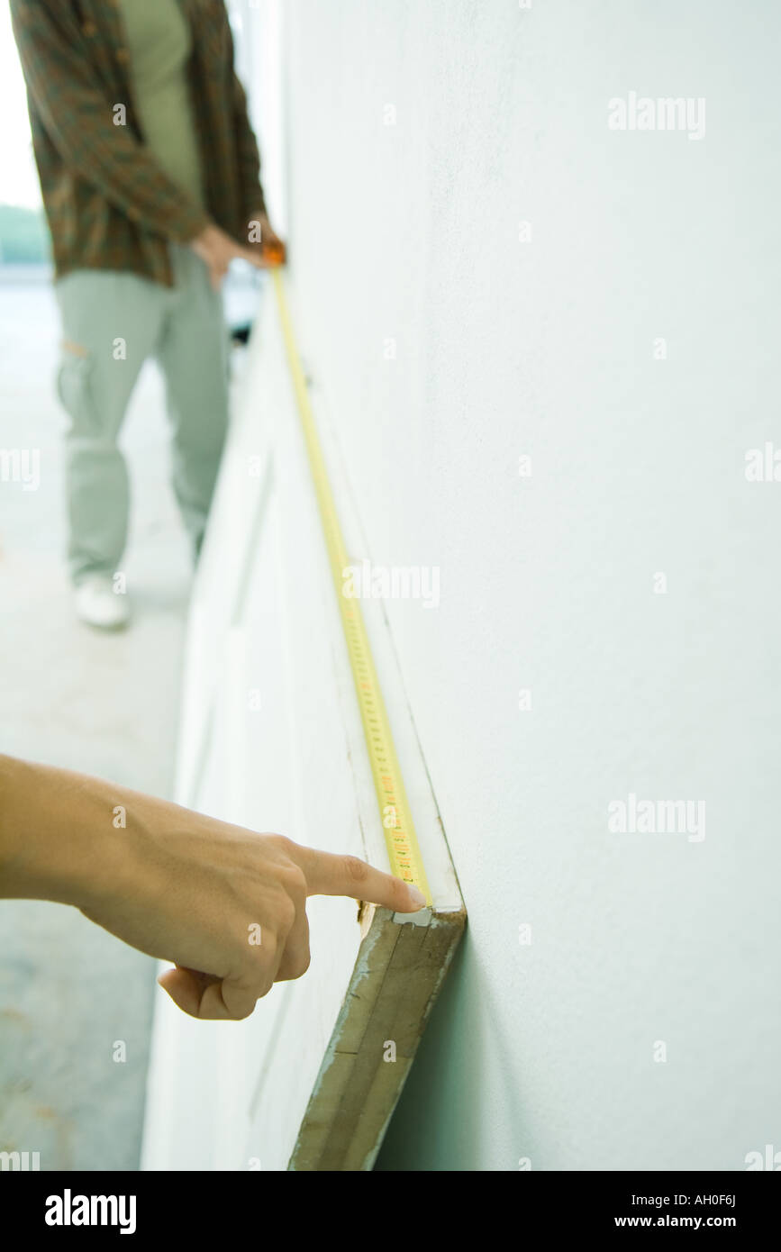 Man and woman measuring door with measuring tape, cropped view Stock ...