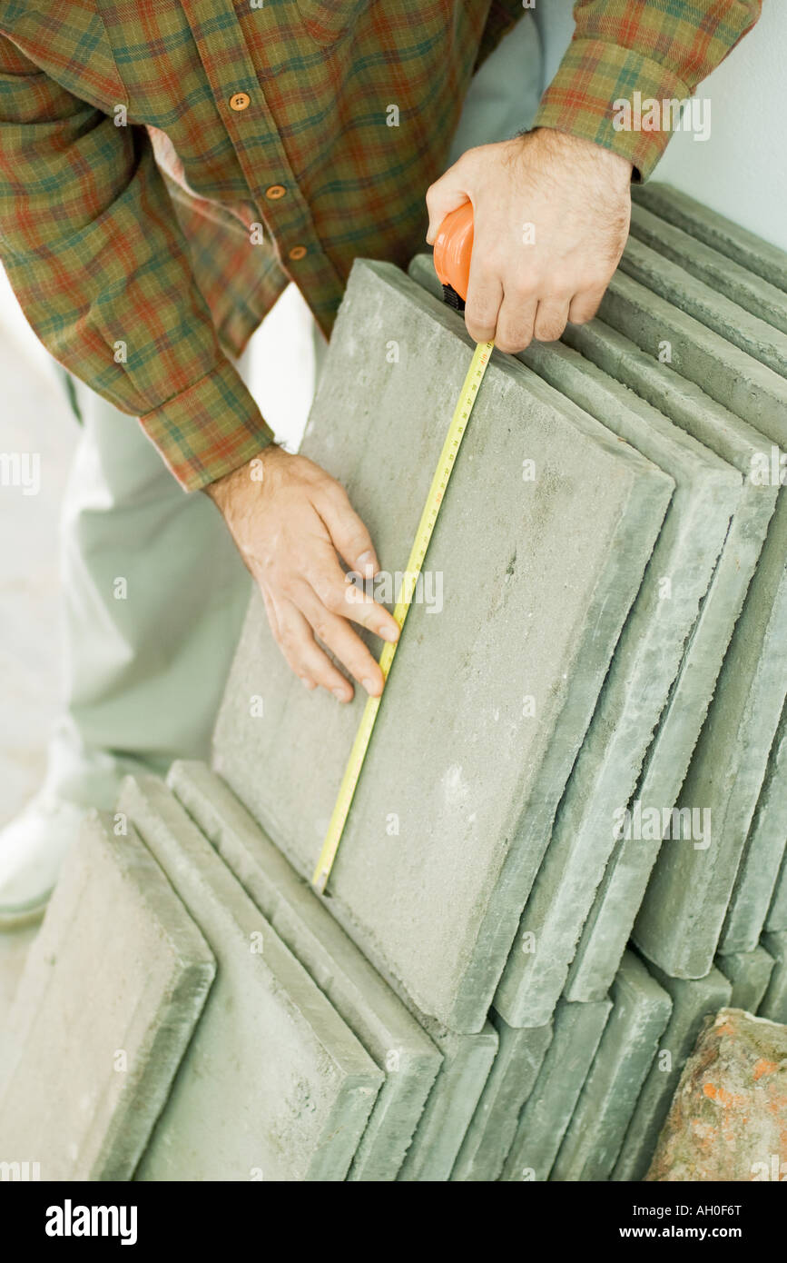 Man measuring paving stone with measuring tape, cropped view Stock ...
