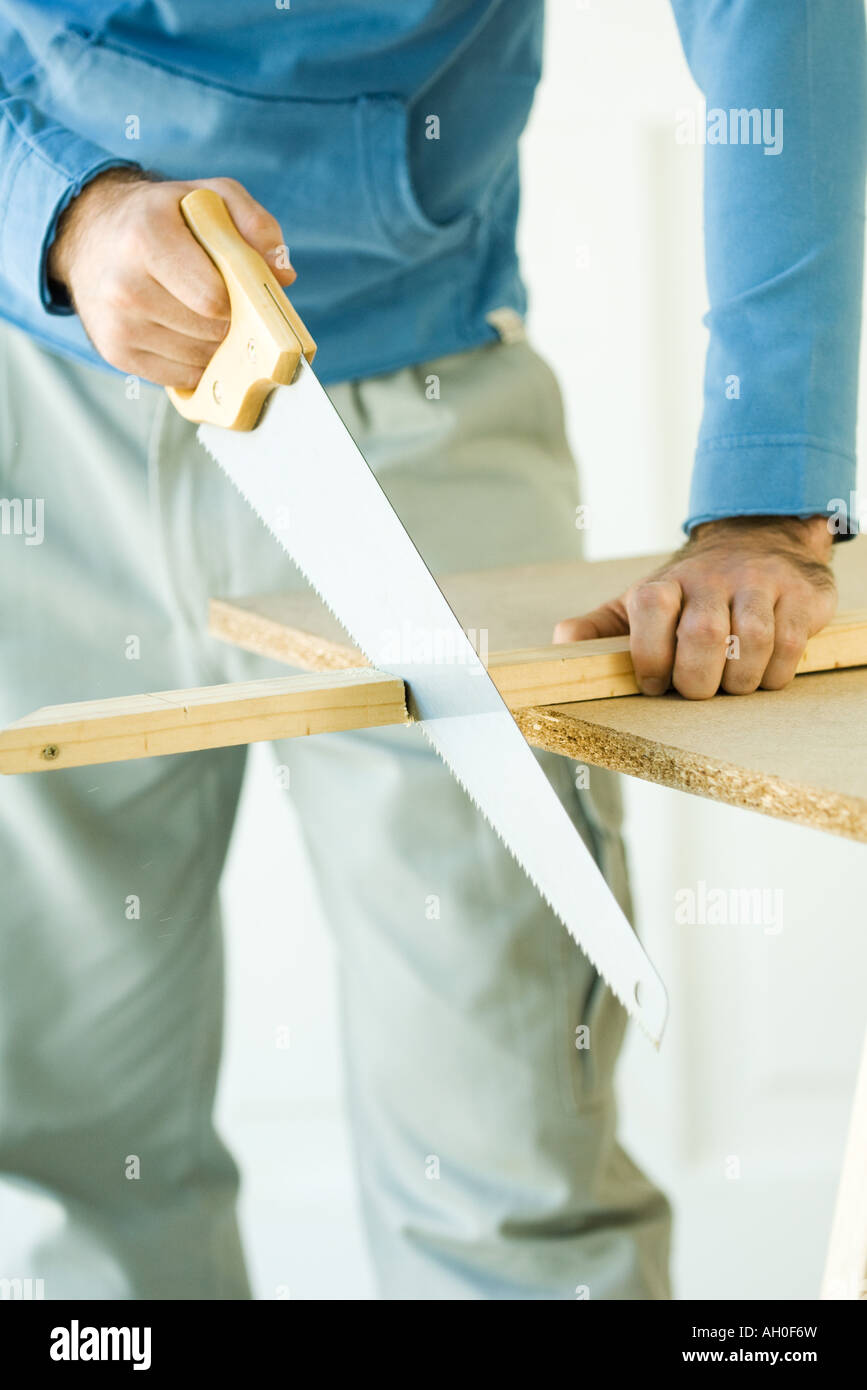 Man sawing wood with saw, cropped view Stock Photo - Alamy