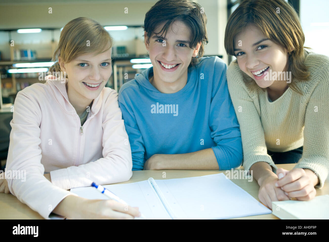 Three students studying together, smiling at camera Stock Photo - Alamy