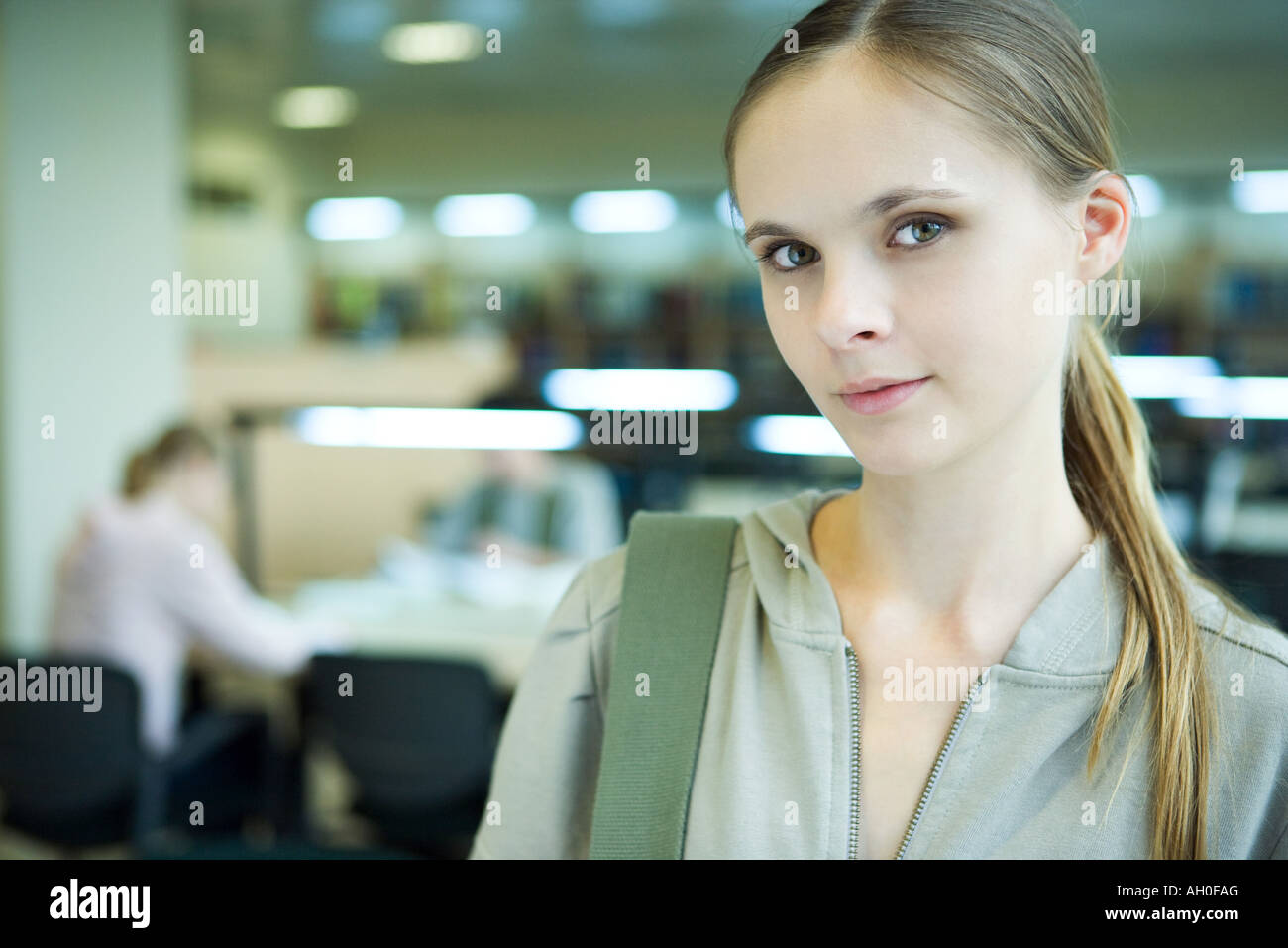 Female student smiling at camera, sideways glance Stock Photo - Alamy