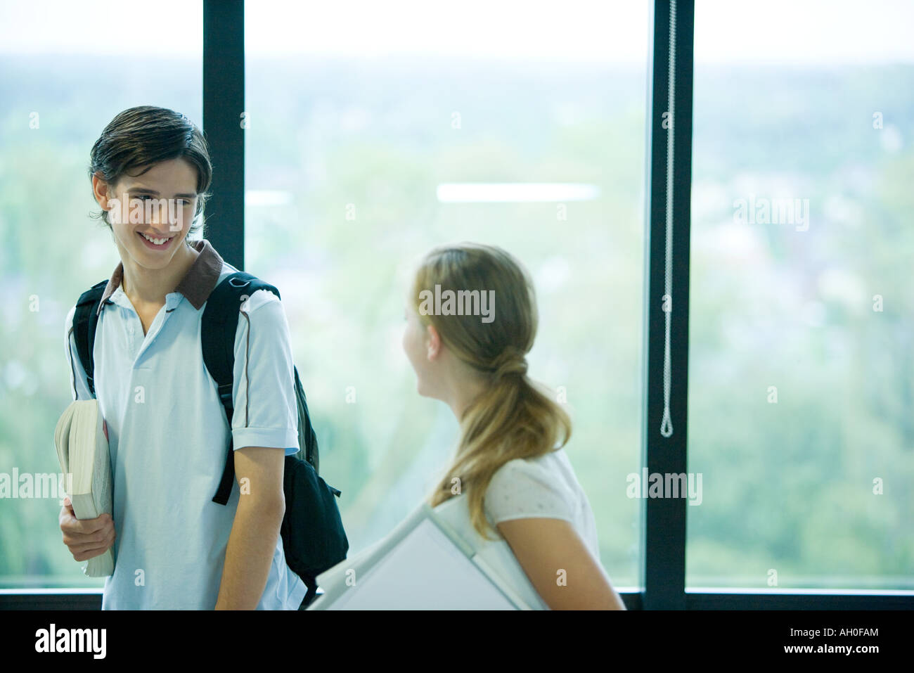 Two students in front of window, looking at each other, smiling Stock ...