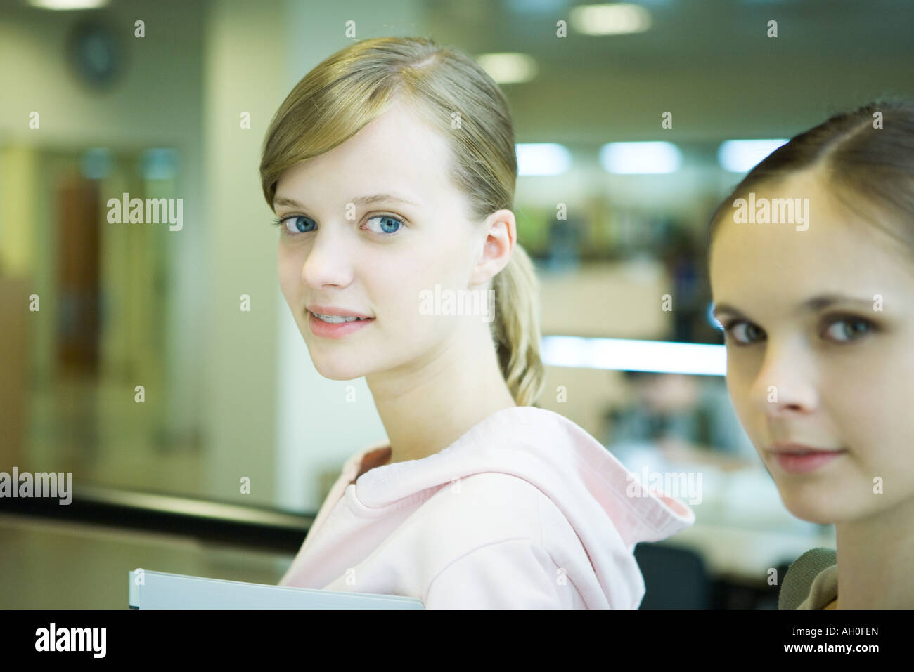Two female students smiling at camera, side view Stock Photo - Alamy
