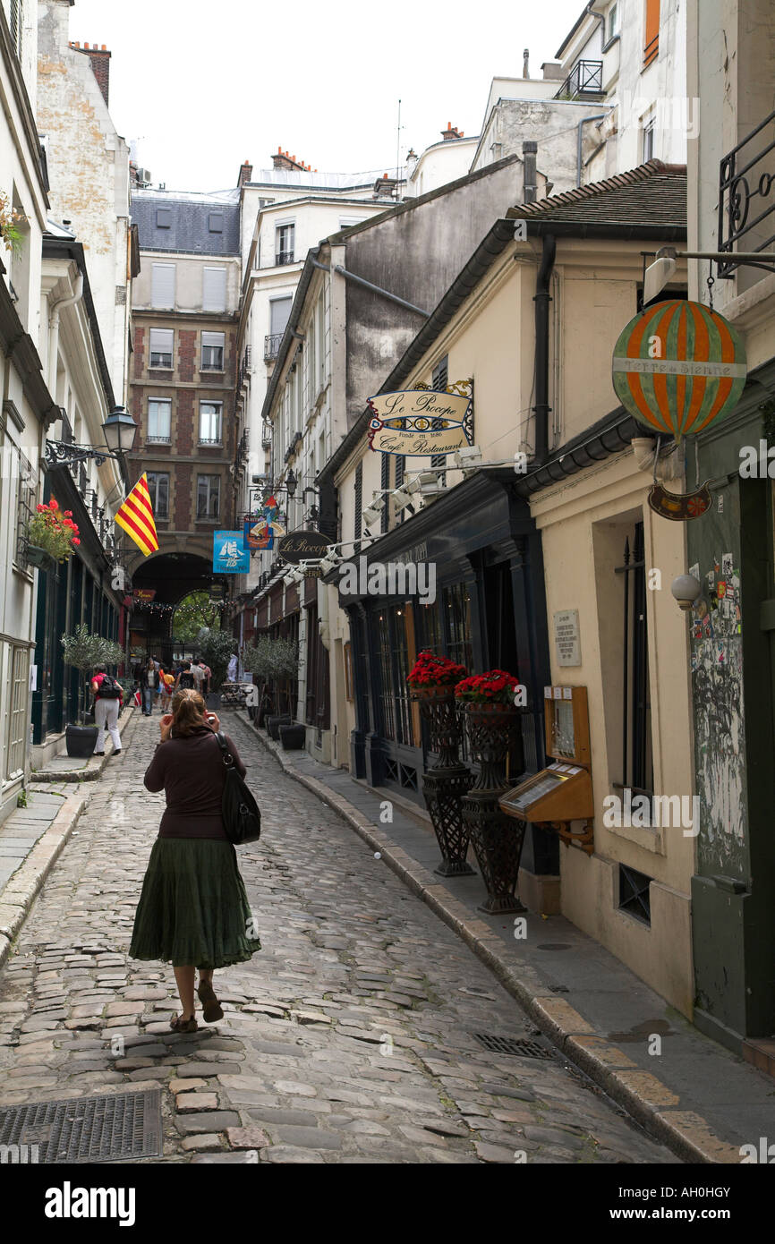 Woman walking in narrow cobbled street in Paris Stock Photo - Alamy