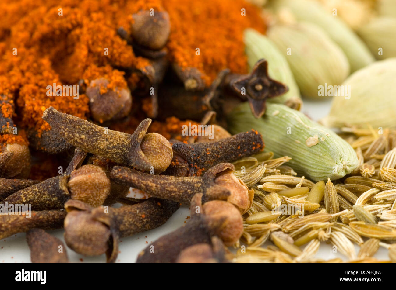 A selection of spices against a white background including cumin seeds ...